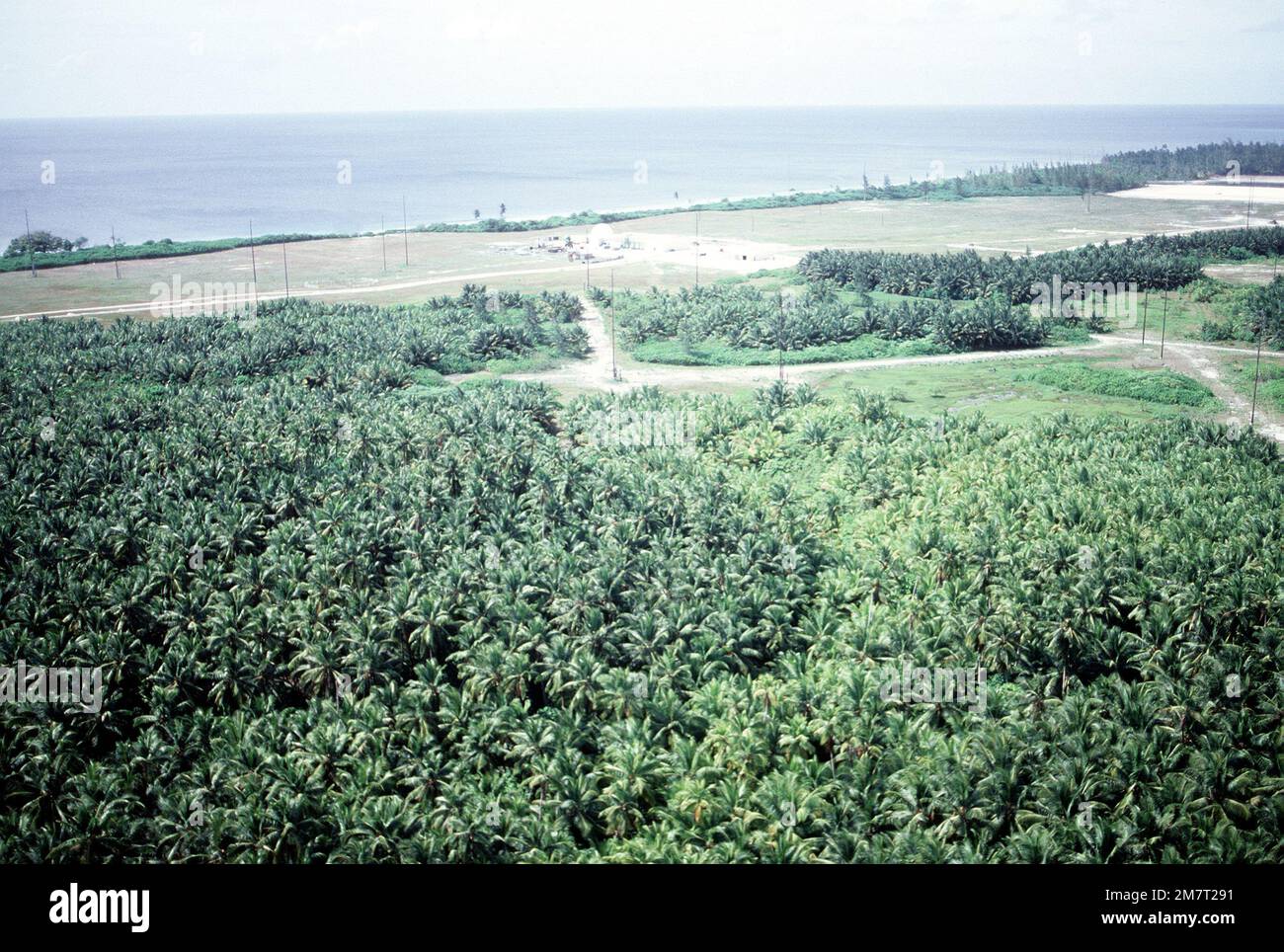 An aerial view, looking toward the sea, of greenery. Base: Nav Sup ...