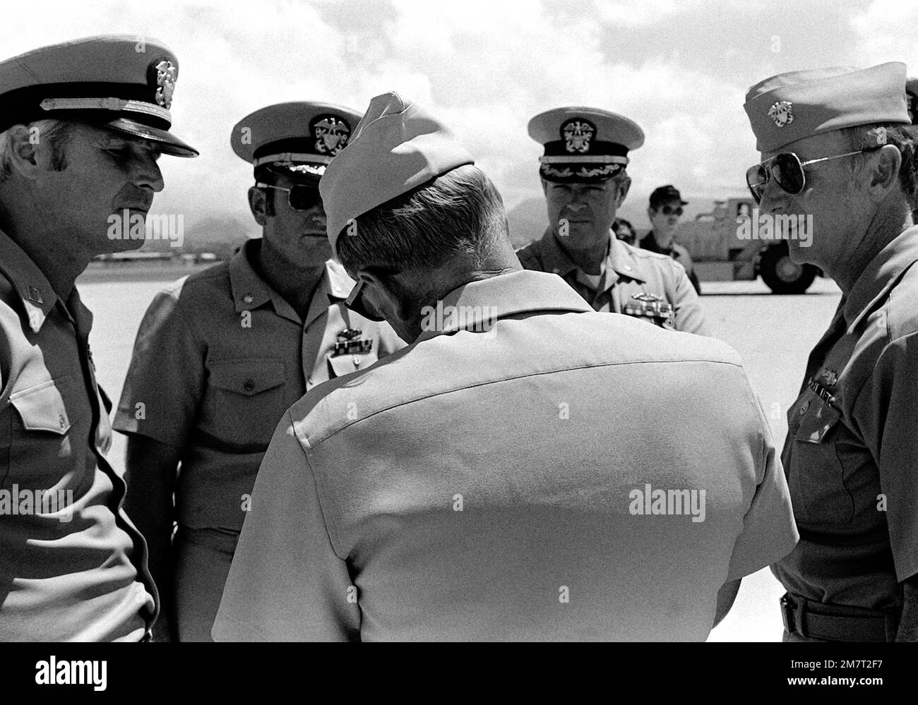 A group of officers chat as they supervise the unloading of the deep ...