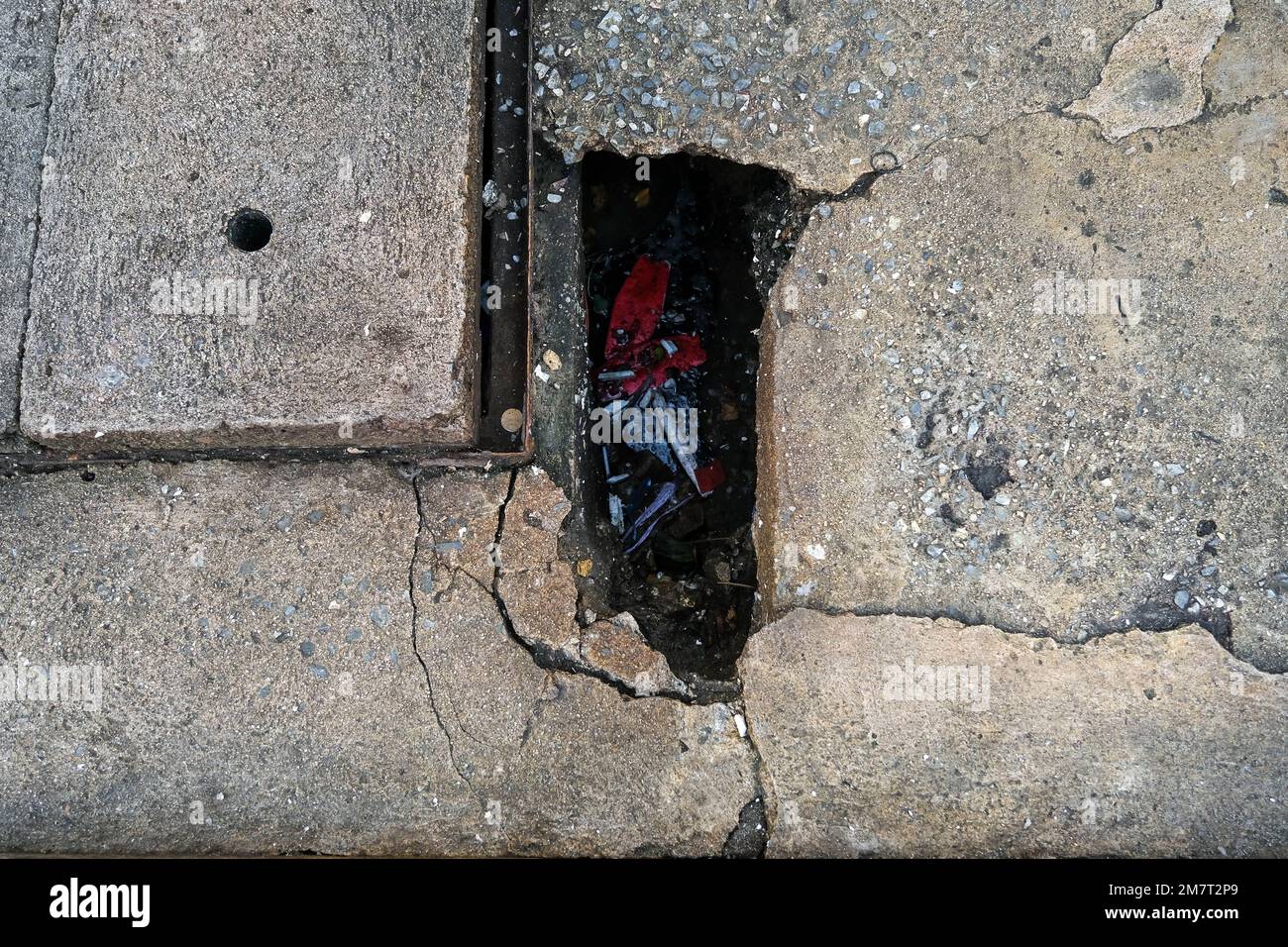 Damaged public sidewalk. Pavement damage. Dangerous sidewalk hole and ...