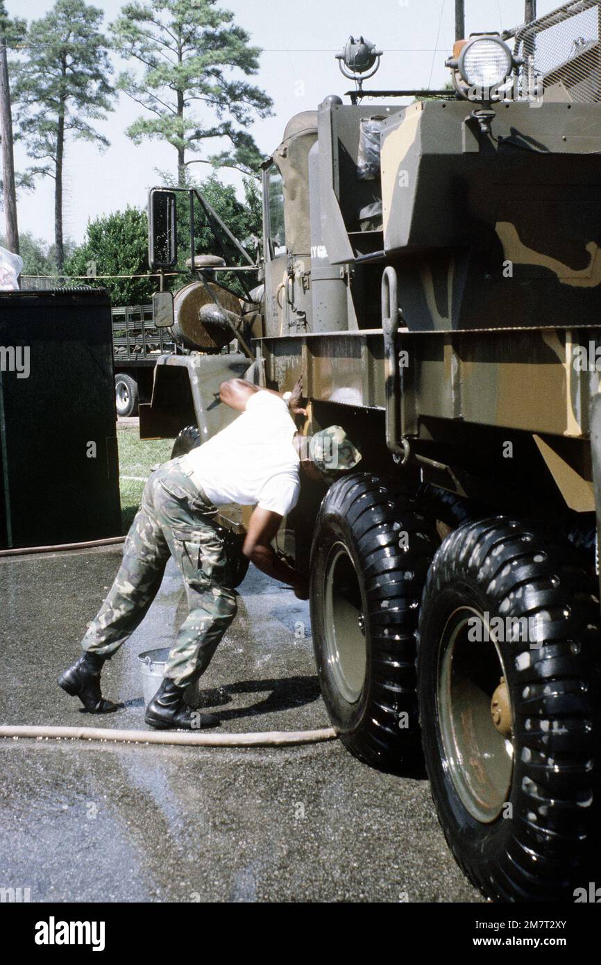A Marine from the 2nd Maintenance Battalion washes a camouflaged 5-ton ...