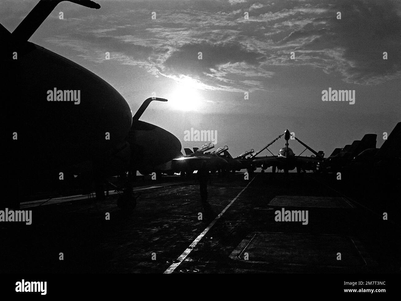 Parked EA-6A Intruder aircraft (foreground) line the deck of the ...