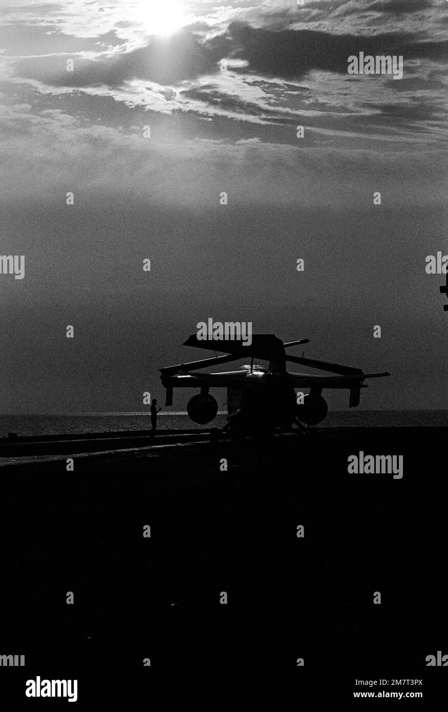 A silhouetted view of an S-3 Viking aircraft, with wings folded, on the ...