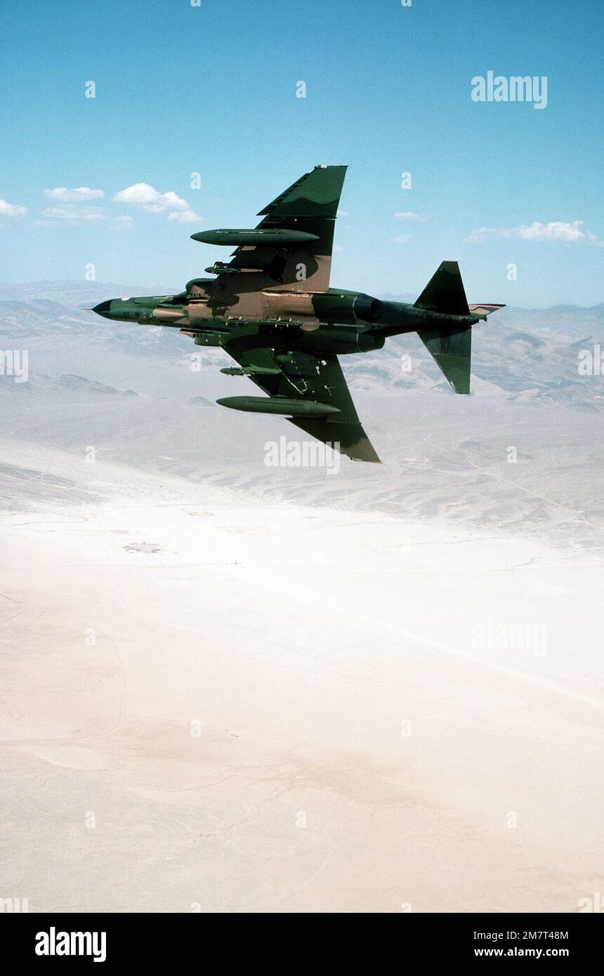 A underside view of an F-4 Phantom II aircraft as it banks to the right ...