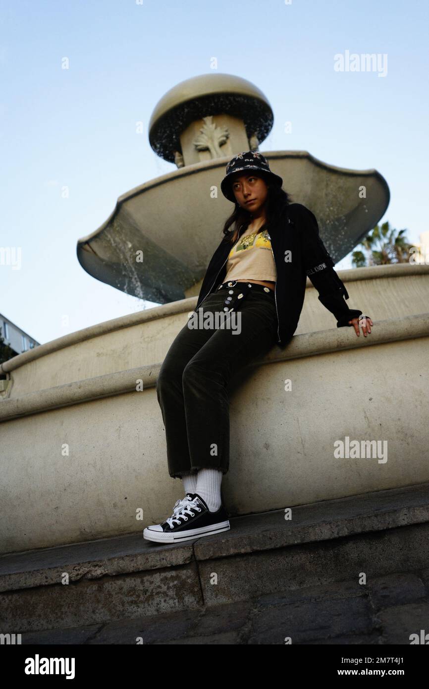 The model is placed in front of a fountain shot with low shutter speed ...
