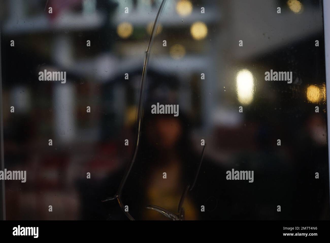 Photo is taken focused on the crack in a very blurry mirror with a ...