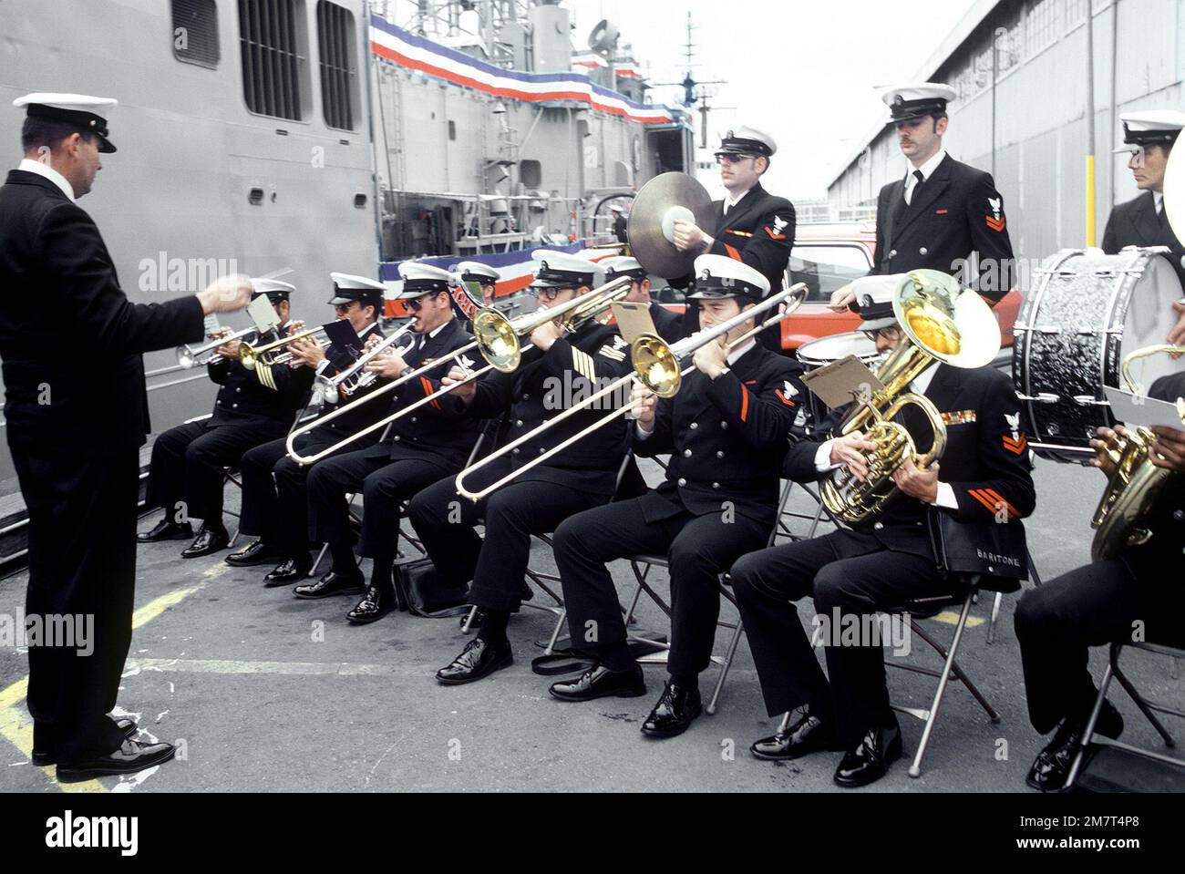 A U.S. Navy band performs on the pier next to the guided missile ...