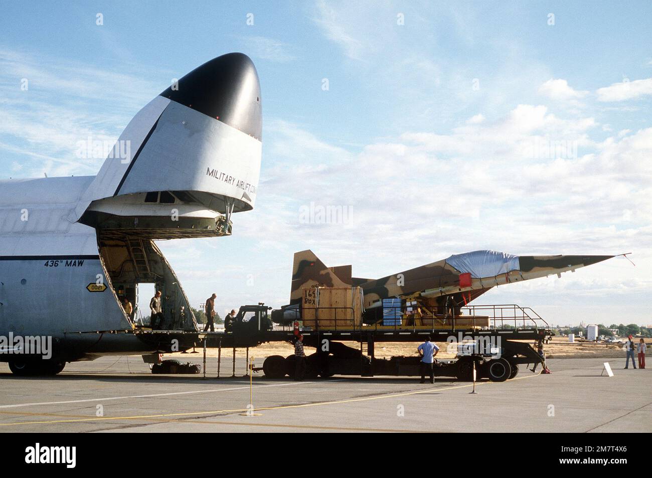 A right side view of an F-5 Tiger II aircraft being loaded aboard a C-5 ...