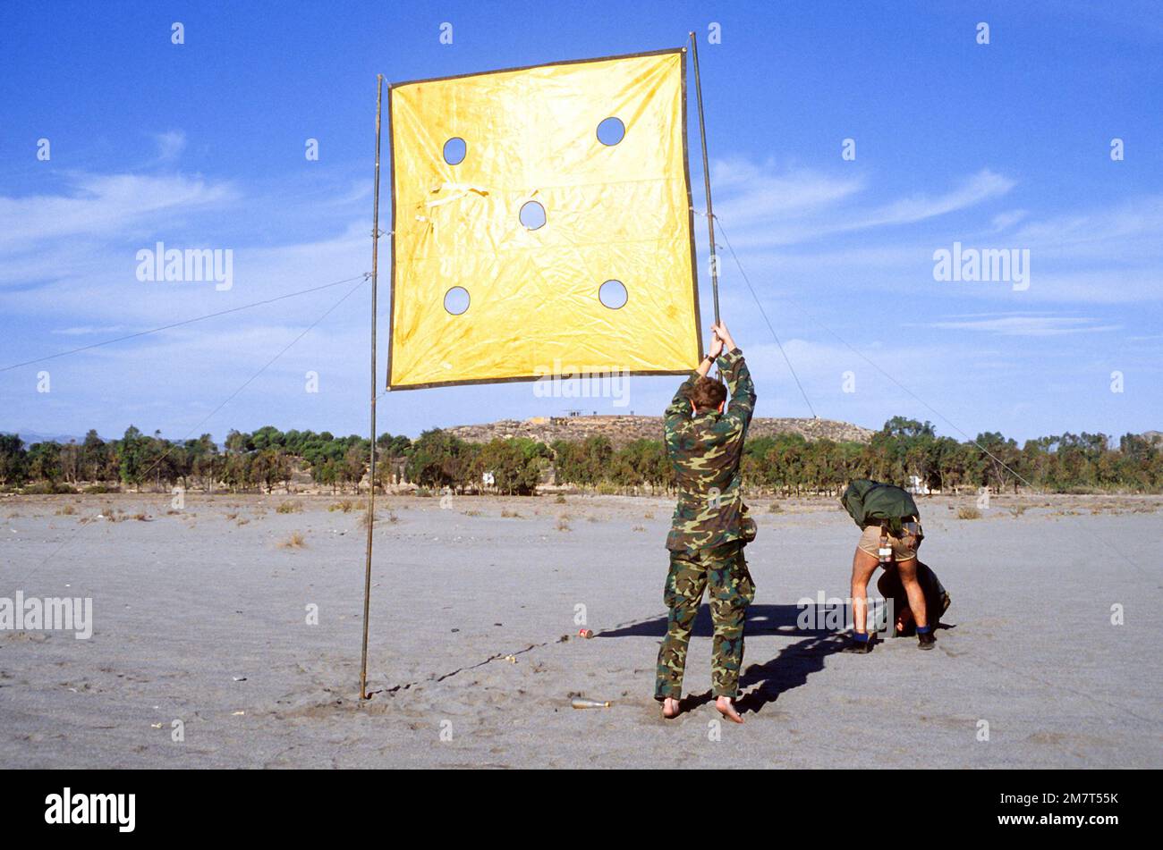 Navy Sea-Air-Land (SEAL) team members set up beach markers for a Marine ...