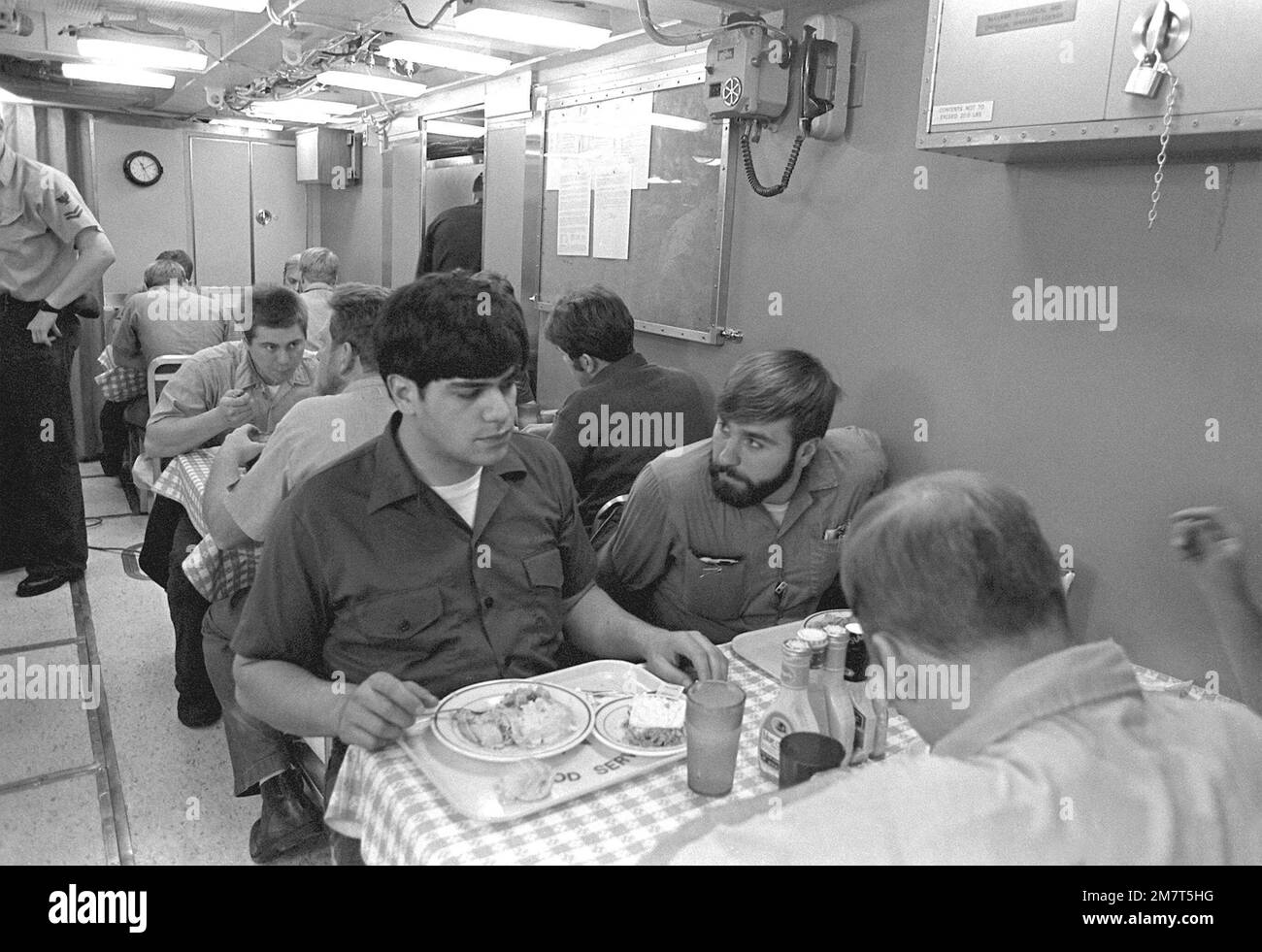 Crewmen eat in the dining hall during precommissioning duty aboard the ...