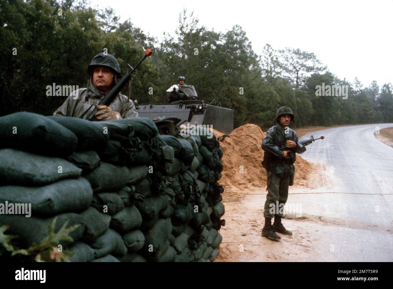 Personnel armed with M16 rifles guard the entry control point to ...