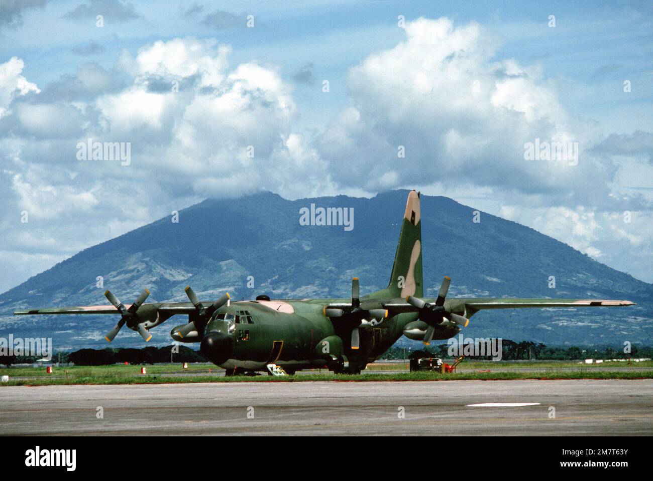A left front view of a C-130E Hercules aircraft parked on the flight ...