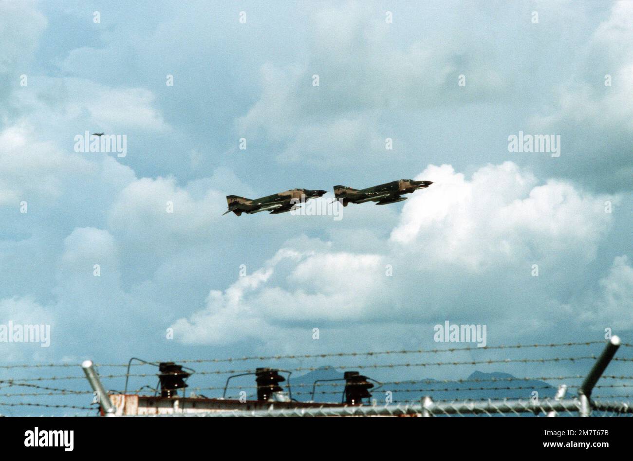 A ground-to-air right side view of two low-flying F-4 Phantom II ...