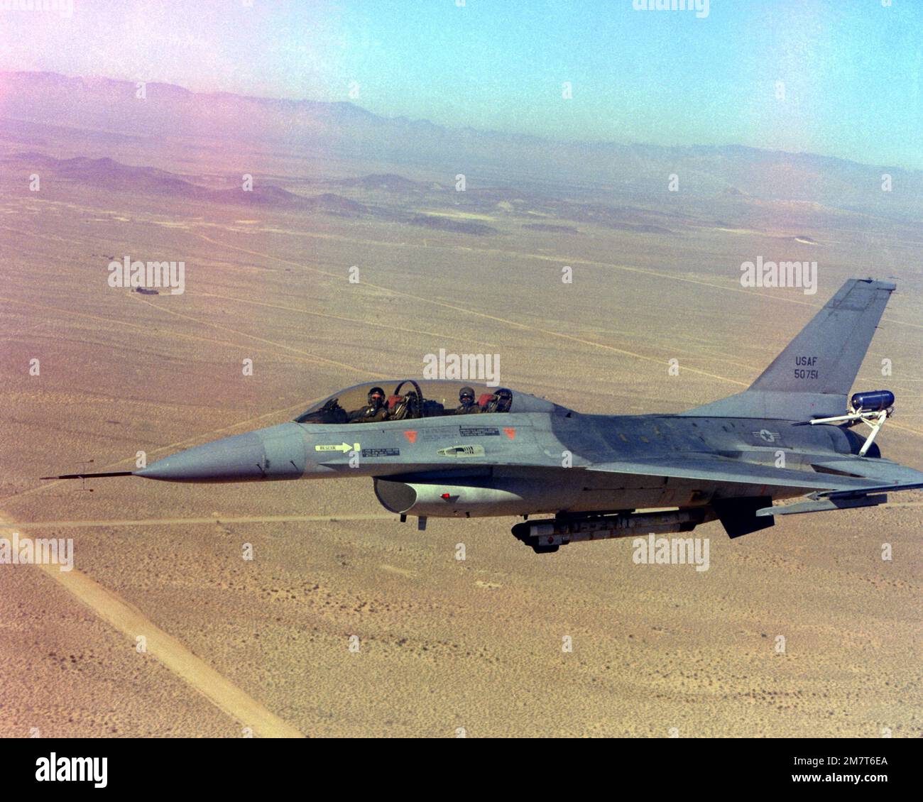 An air-to-air left front view of an F-16B Fighting Falcon aircraft with ...