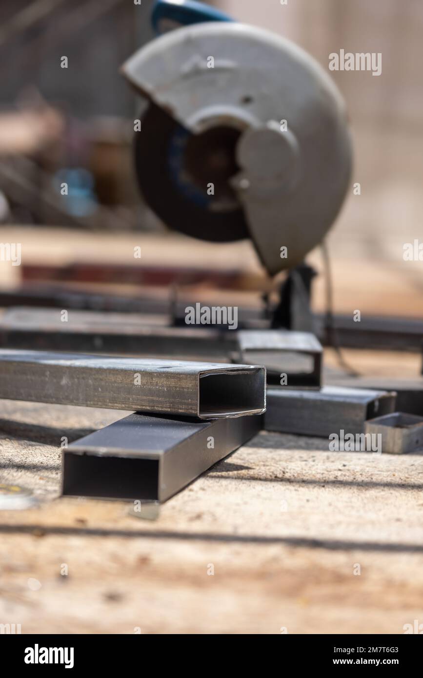Blade saw cutting steel rectangular pipe in construction site Stock ...