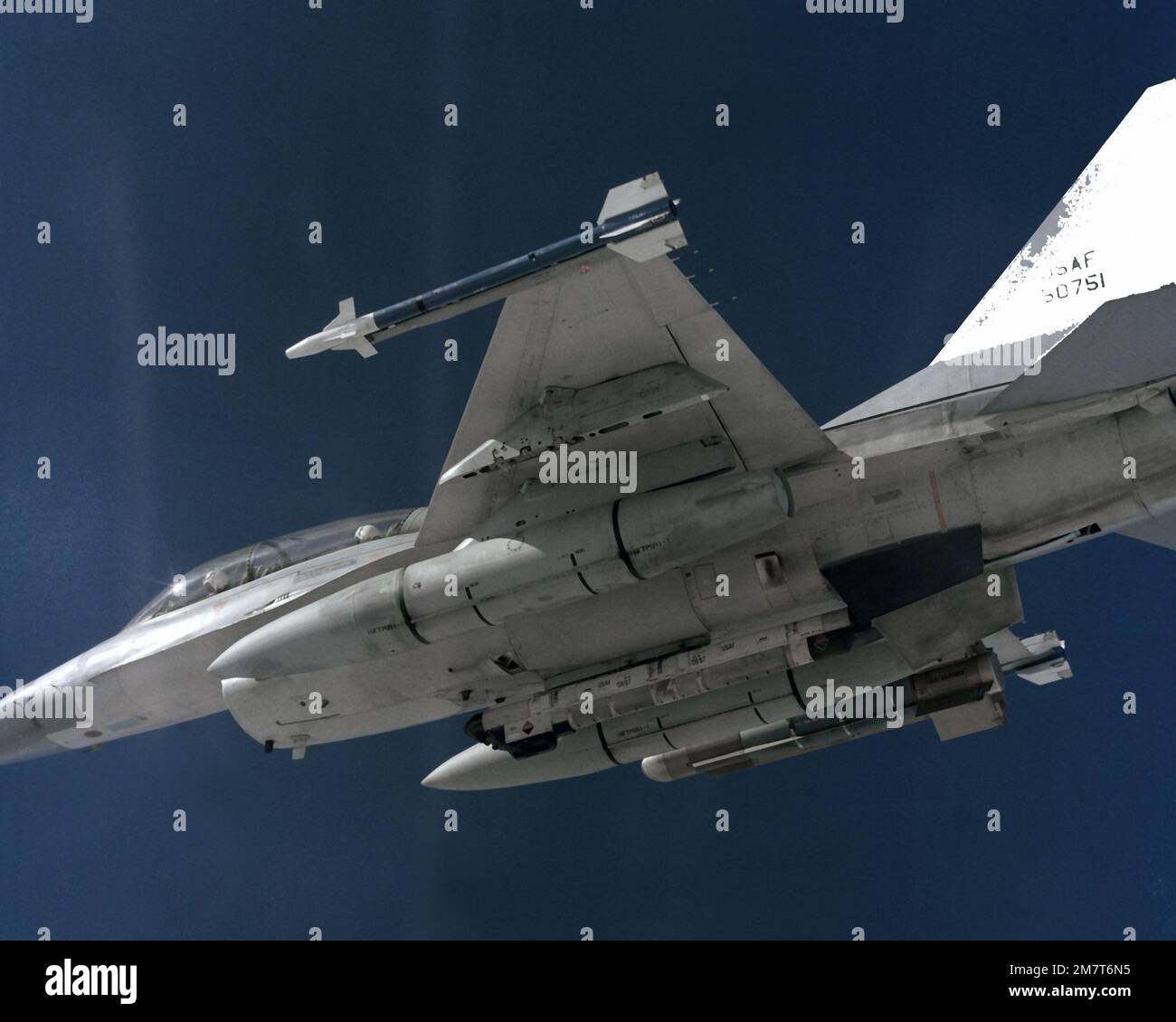 An air-to-air left underside view of an F-16B Fighting Falcon aircraft ...