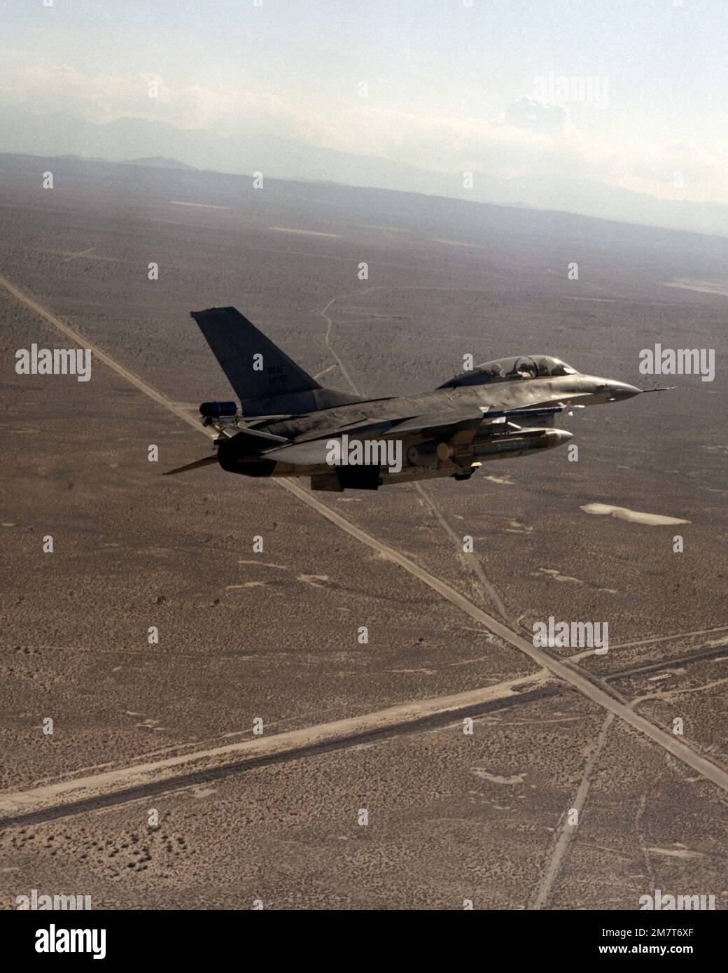 An air-to-air right rear side view of an F-16B Fighting Falcon aircraft ...