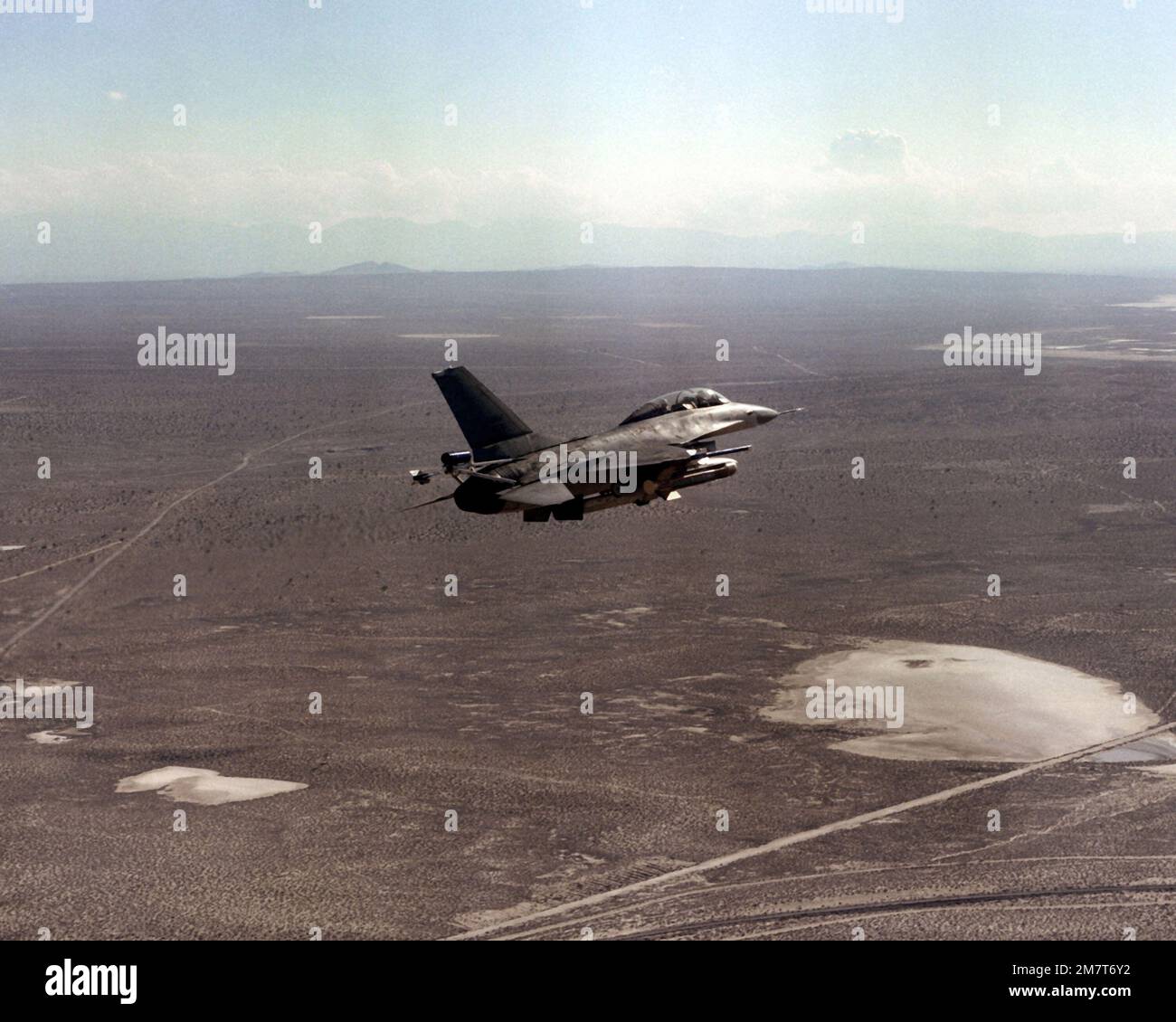 An air-to-air right rear view of an F-16B Fighting Falcon aircraft with ...