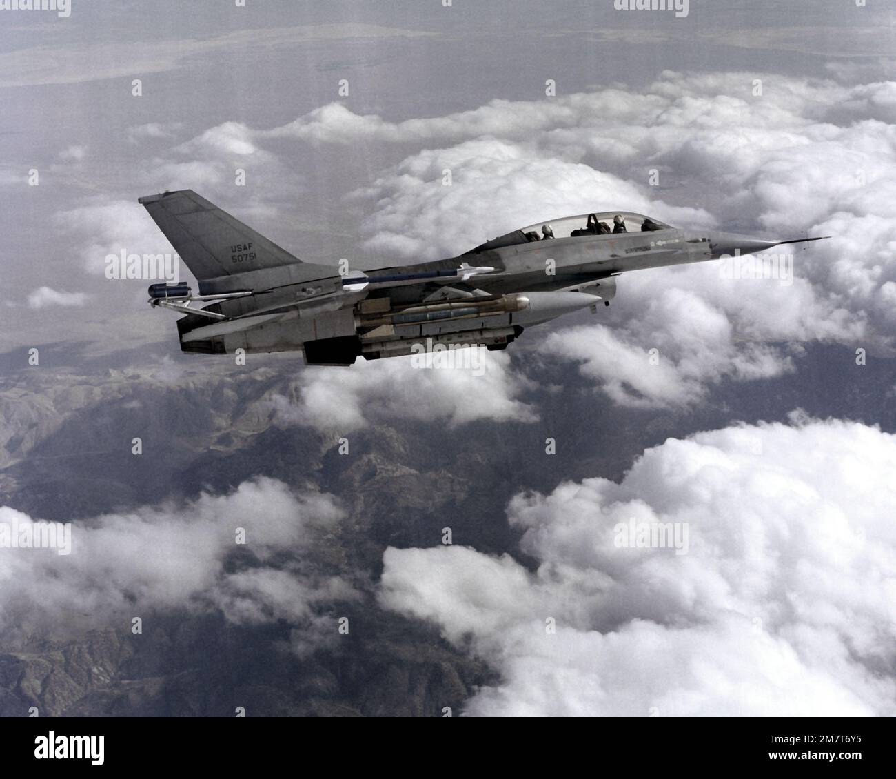 An air-to-air right side view of an F-16B Fighting Falcon aircraft with ...