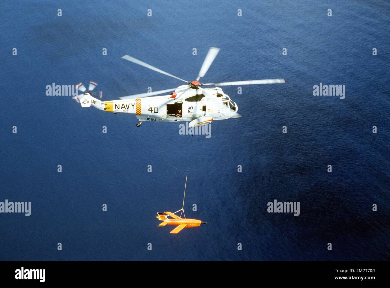 An air-to-air view of an SH-3 Sea King helicopter airlifting a Firebee ...