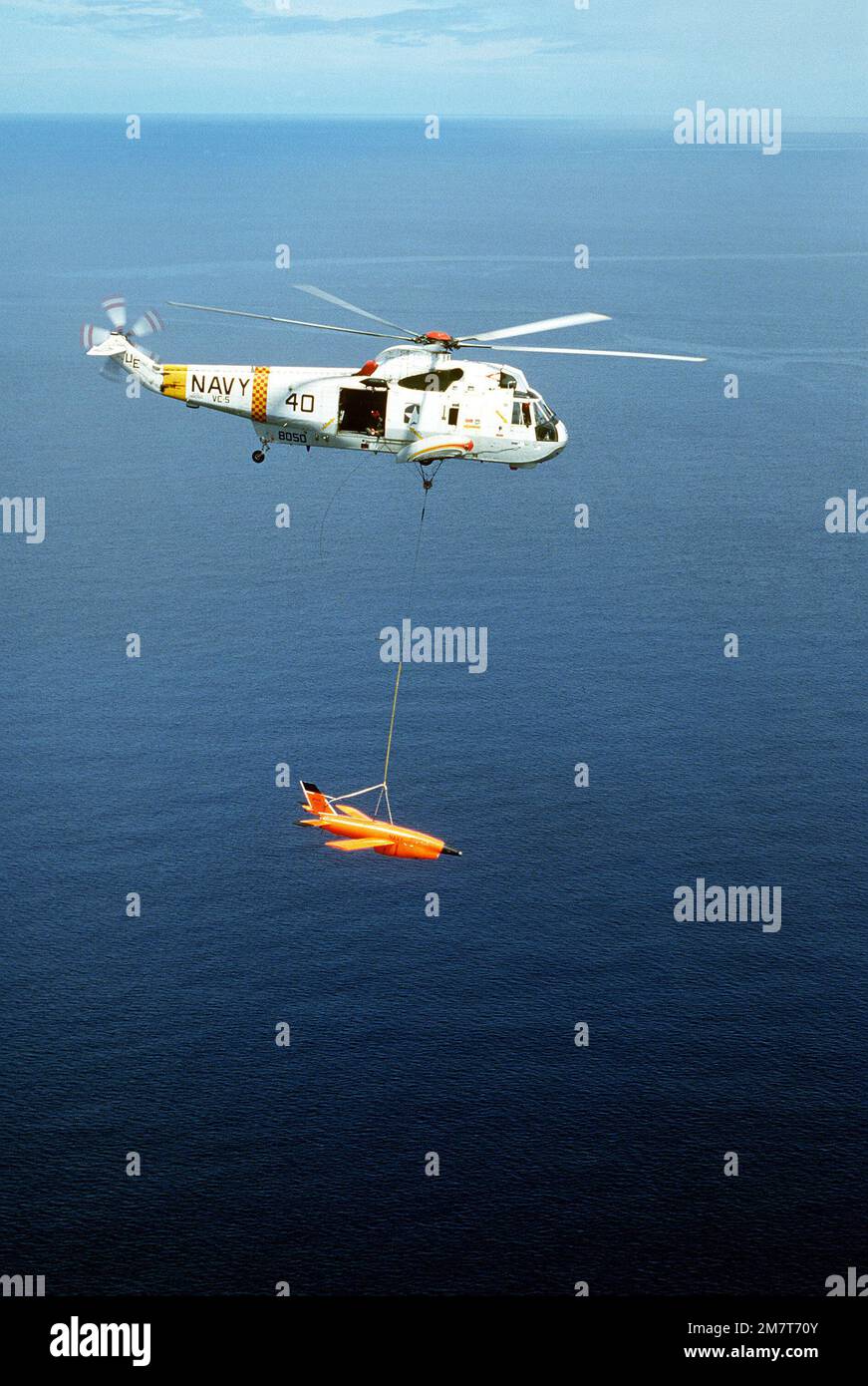 An air-to-air view of an SH-3 Sea King helicopter airlifting a Firebee ...