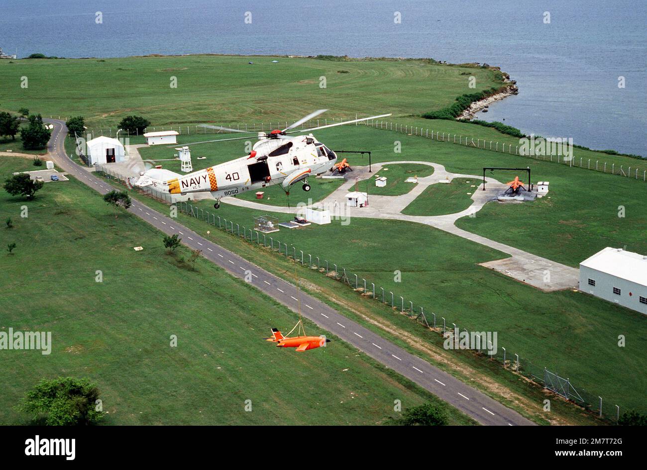 An air-to-air right side view of an SH-3 Sea King helicopter airlifting ...