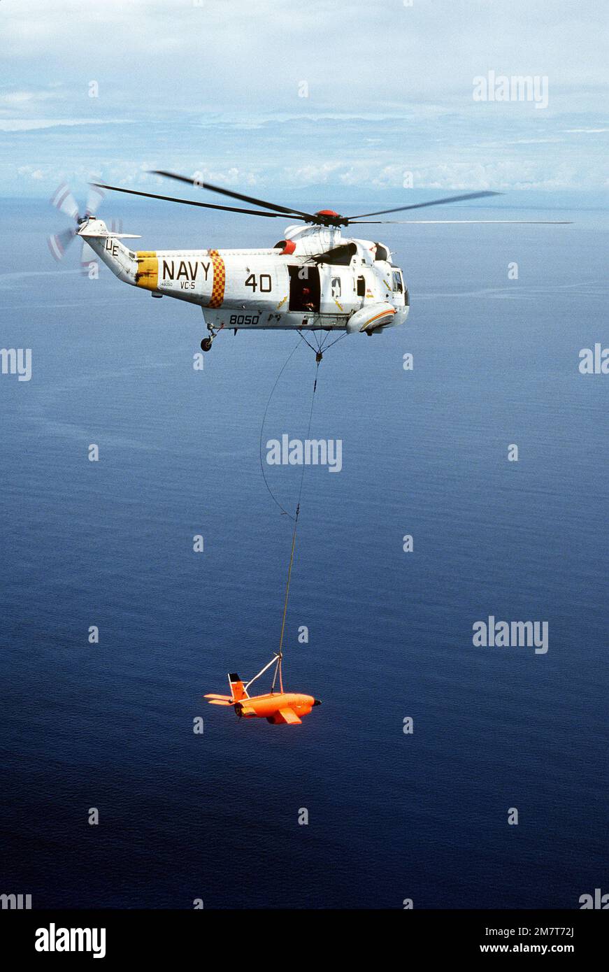 A air-to-air view of an SH-3 Sea King helicopter airlifting a Firebee ...