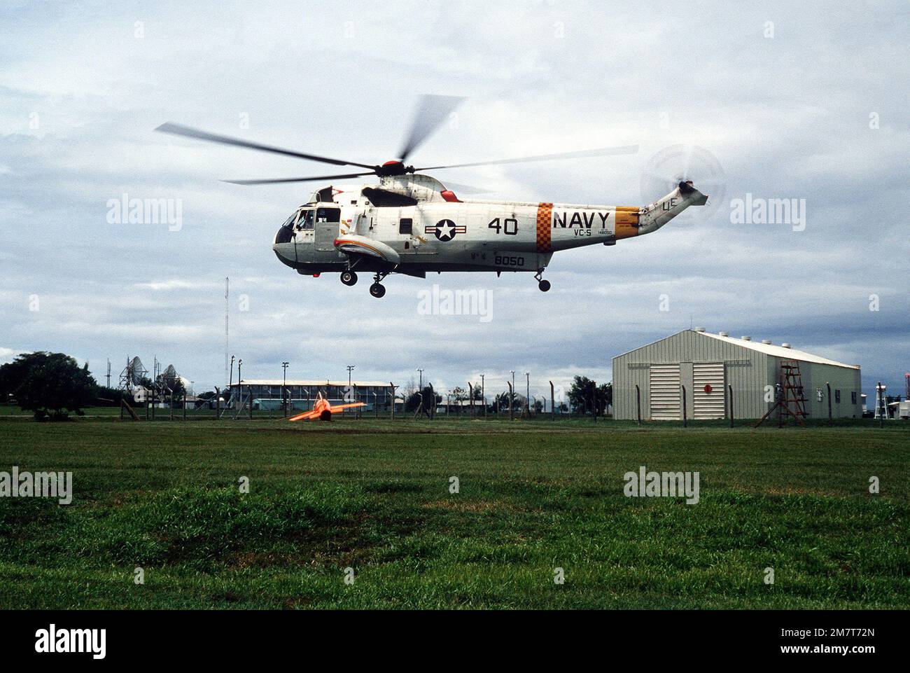 A ground-to-air left side view of an SH-3 Sea King helicopter hovering ...