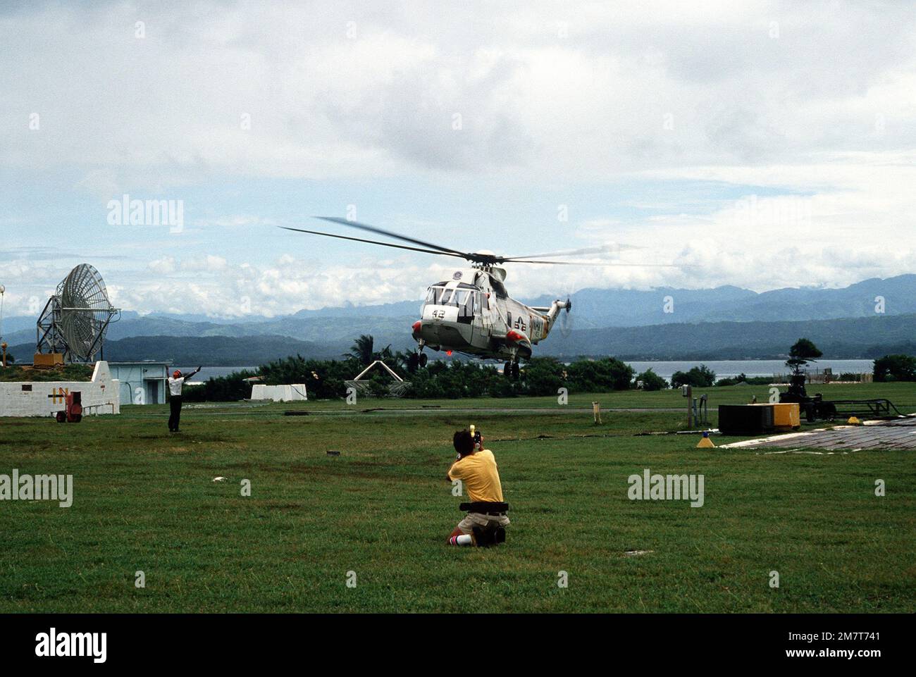 A member of the Pacific Fleet Audio Visual Command films an SH-3 Sea ...