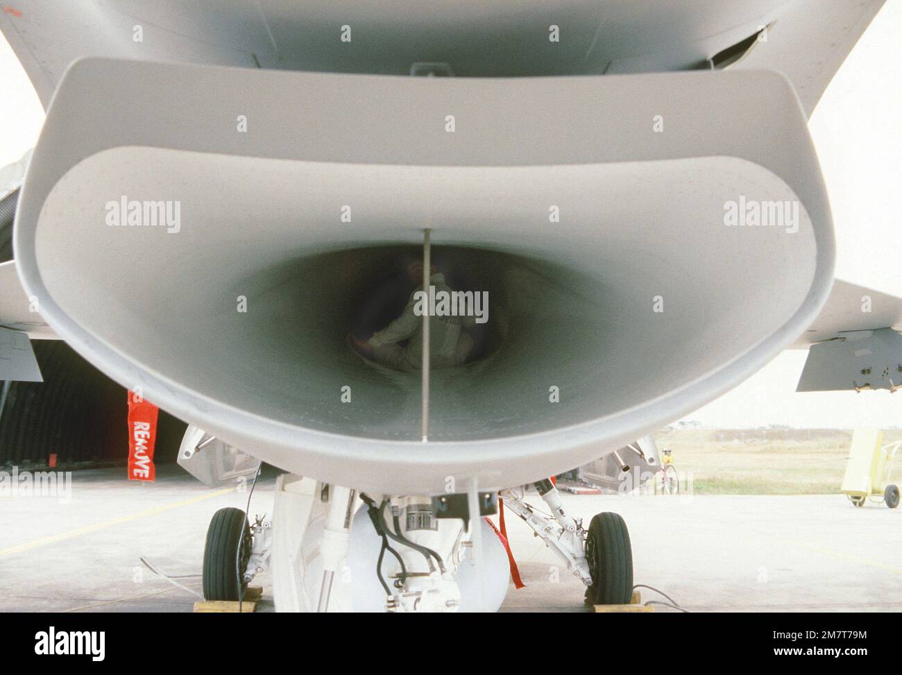 A specialist performs maintenance inside the intake of an F-16 Fighting ...
