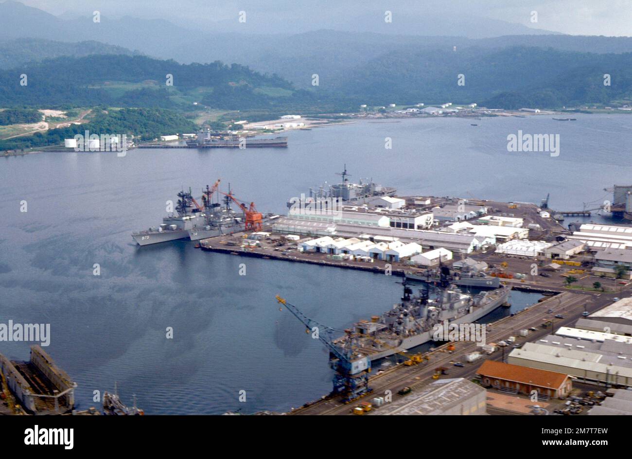 An aerial view of the harbor with docked ships, including the guided ...