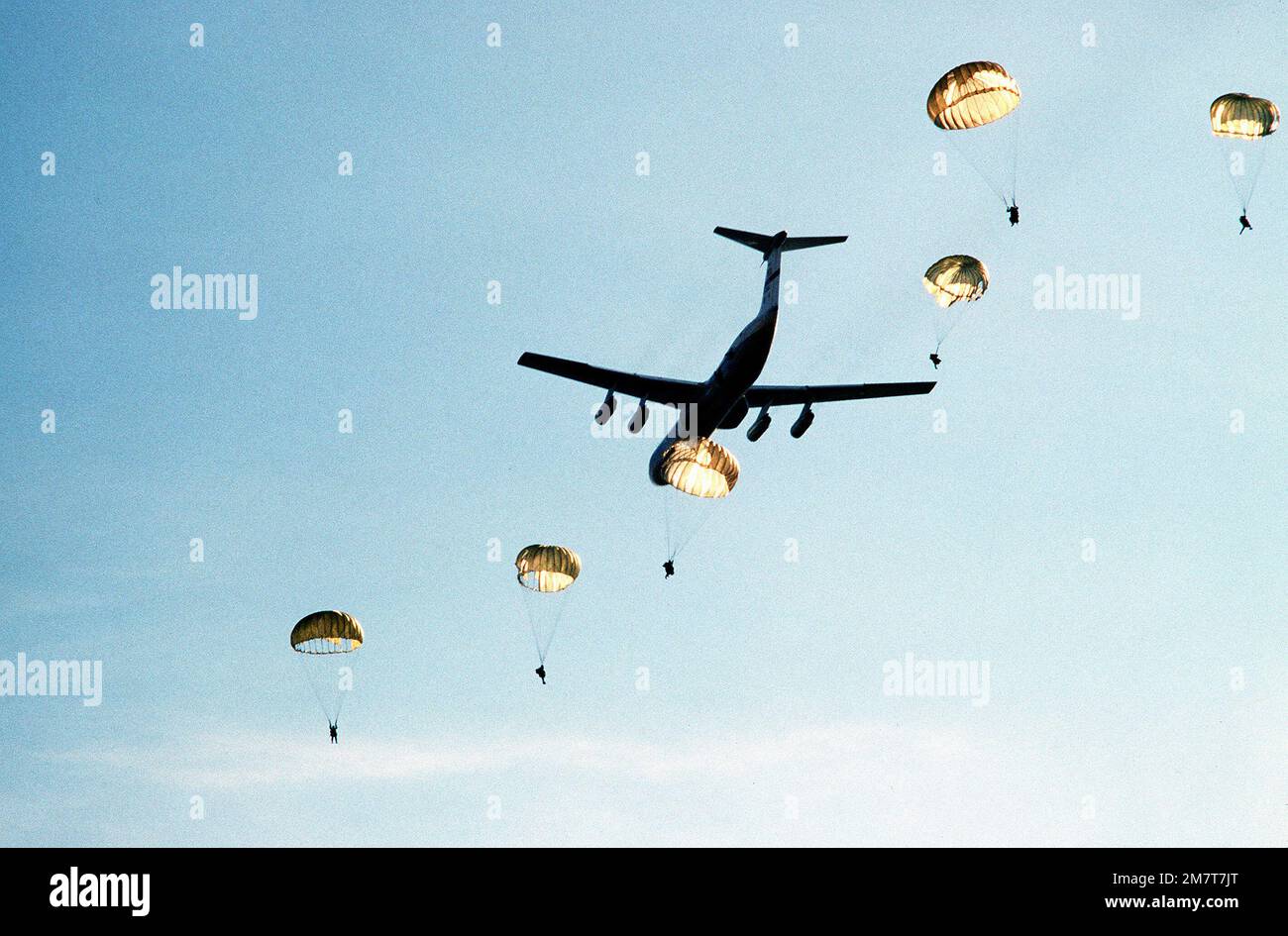 A C-141 Starlifter aircraft drops troops over the drop zone during ...