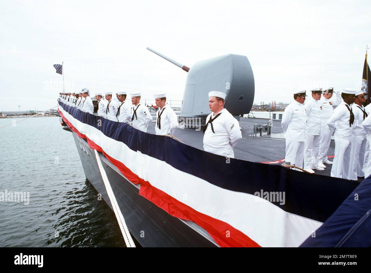 Crew members man the port rail during the commissioning of the guided ...