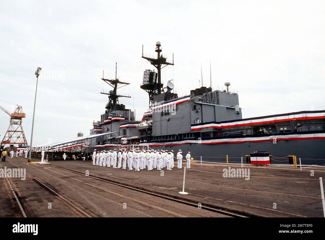Crew members stand at parade rest during commissioning of the guided ...