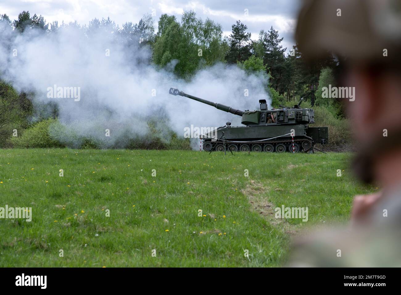 A U.S. Soldier watches Ukrainian artillerymen fire the M109 self-propelled howitzer at ...