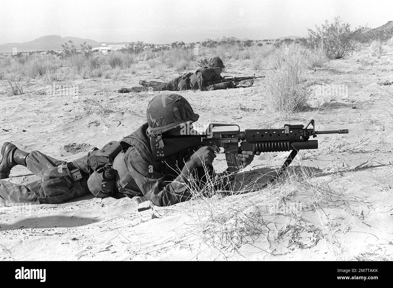 Two combat ready Marines are in the prone position with their M-16A1 ...