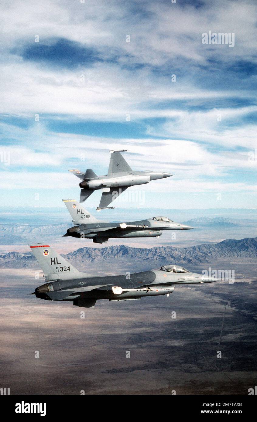An air-to-air right side view of three F-16 Fighting Falcon aircraft ...