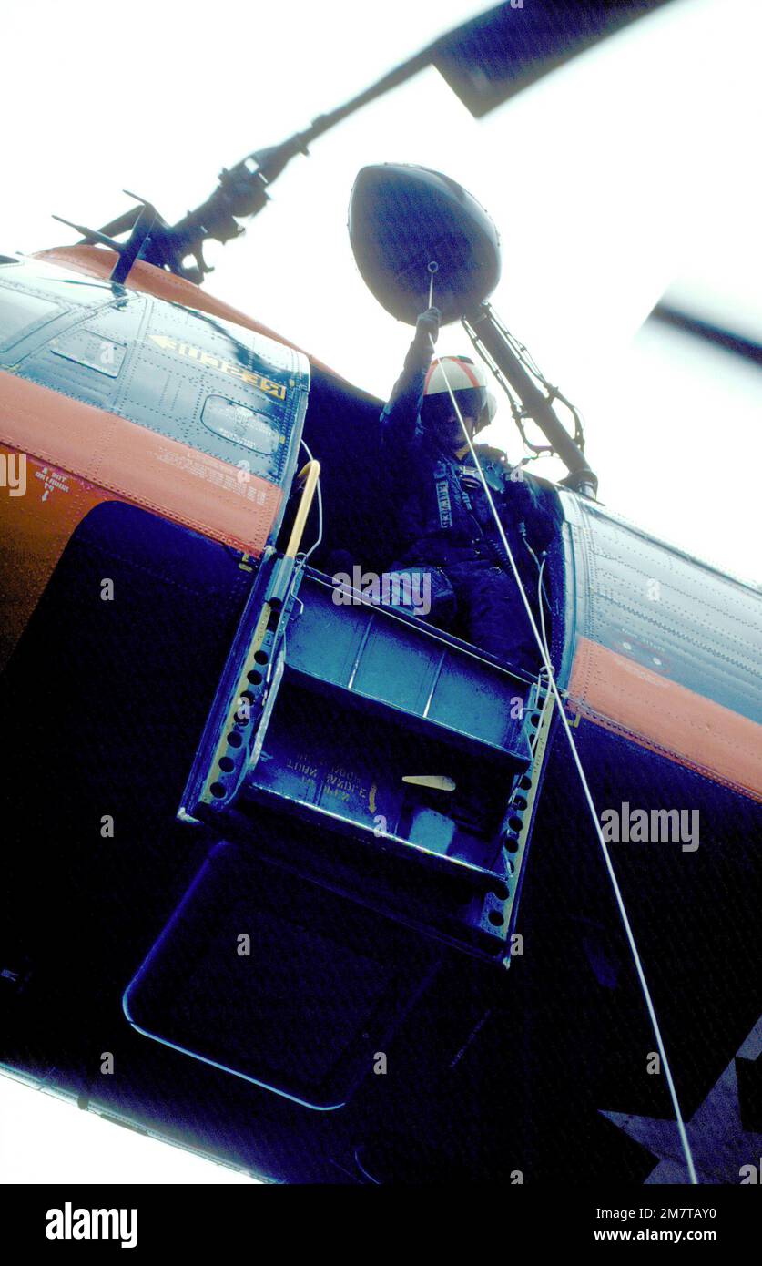 An aircrewman lowers the hoistline from an H-46 Sea Knight helicopter ...