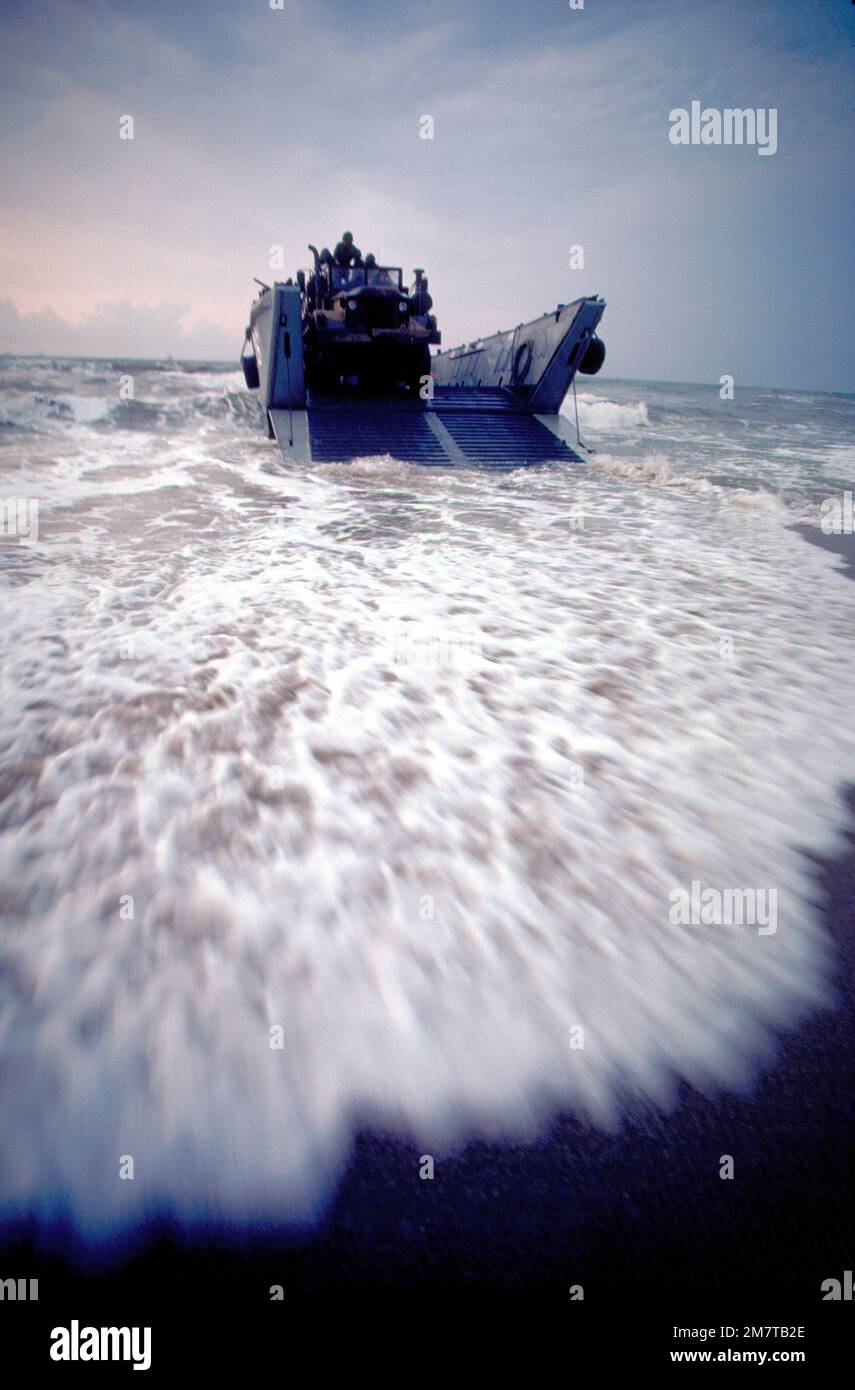 An LCM-8 mechanized landing craft (Mark VIII) hits the beach during ...
