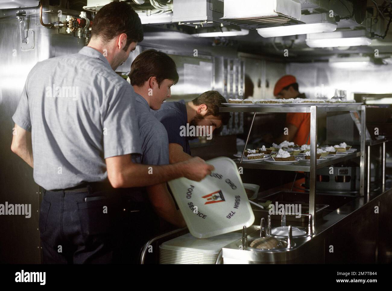 Crewmen stand in line to get a meal in the crew mess aboard the nuclear ...