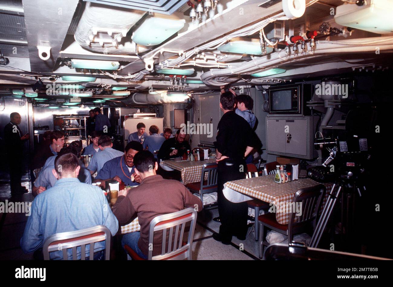 Crewmen eat in the dining hall during precommissioning duty aboard the ...