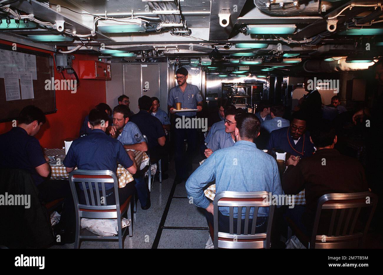 Crewmen eat in the crew's mess during precommissioning duty aboard the ...