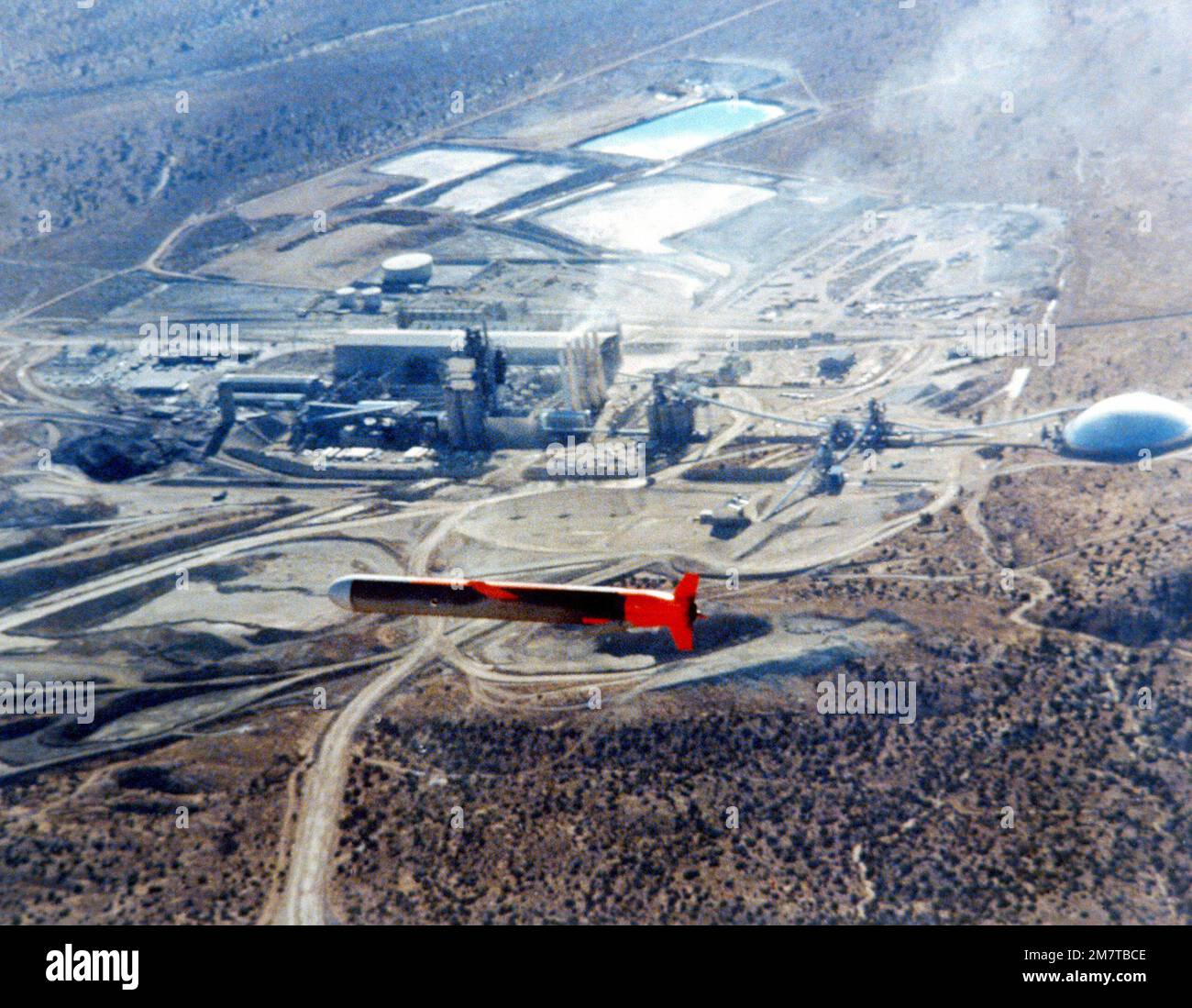 A U.S. Navy Tomahawk cruise missile flies by an isolated industrial ...