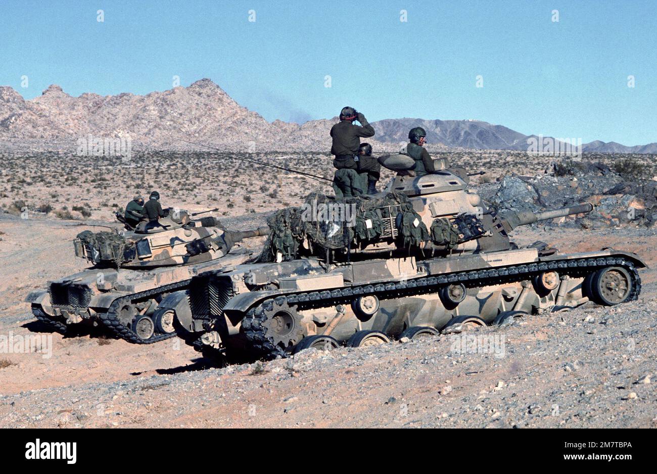 Commanders of two M60A1 tanks stop and check the terrain during ...