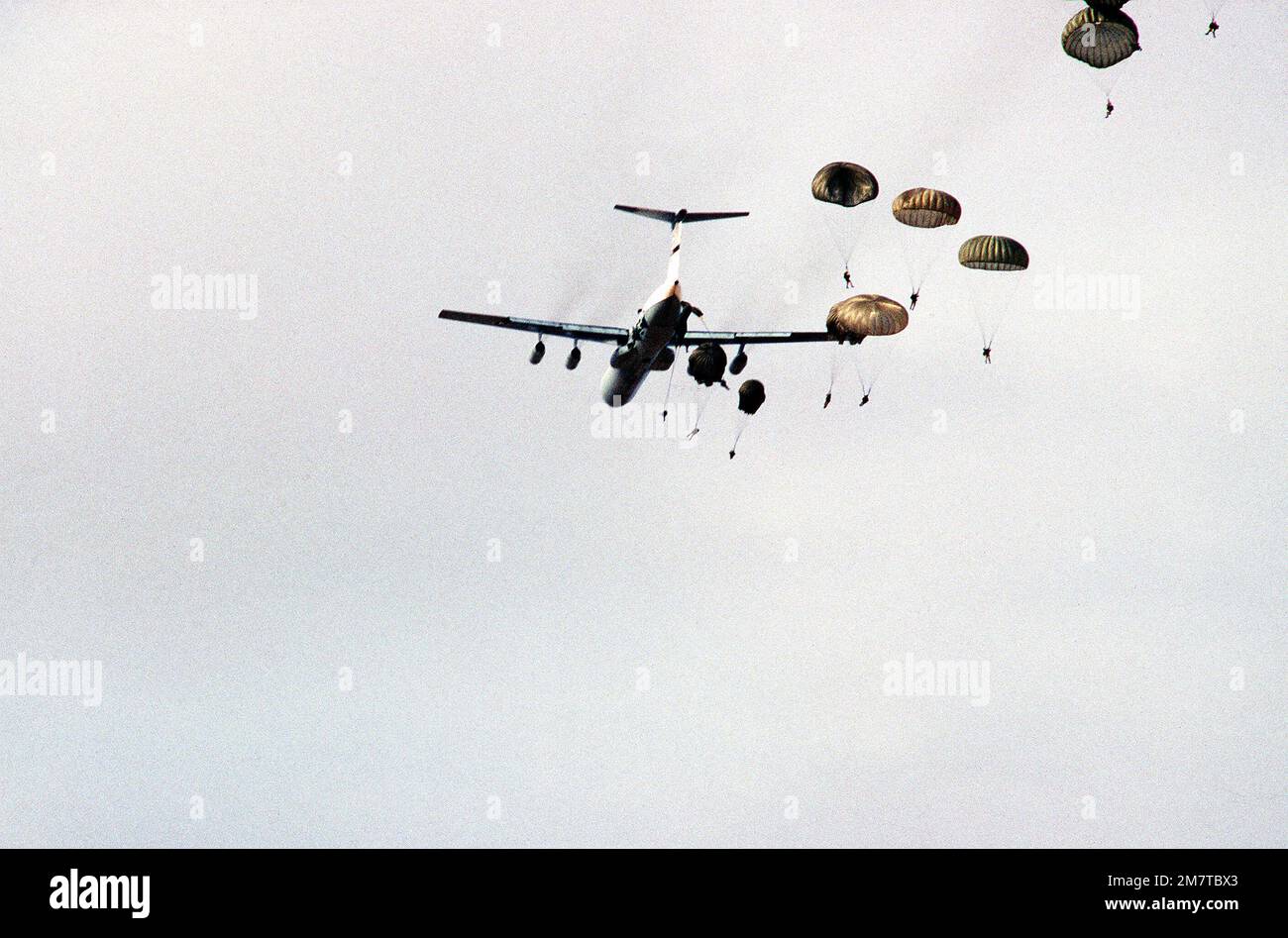 Parachutes open as a C-141 Starlifter aircraft drops personnel during ...