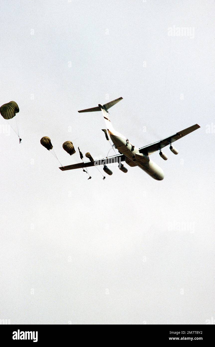 Parachutes open as a C-141 Starlifter aircraft drops personnel during ...