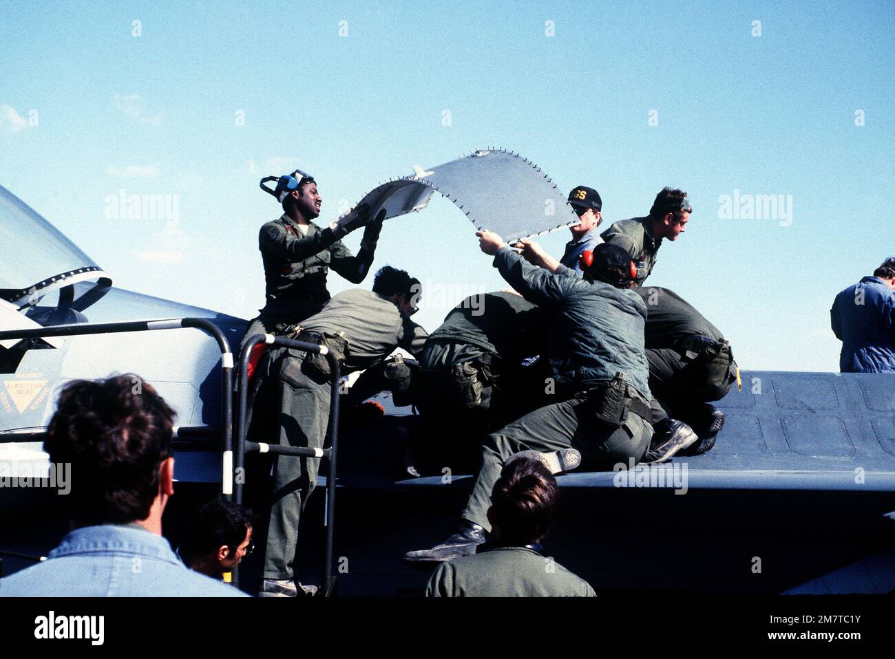 Military personnel perform maintenance on an F-16 Fighting Falcon ...
