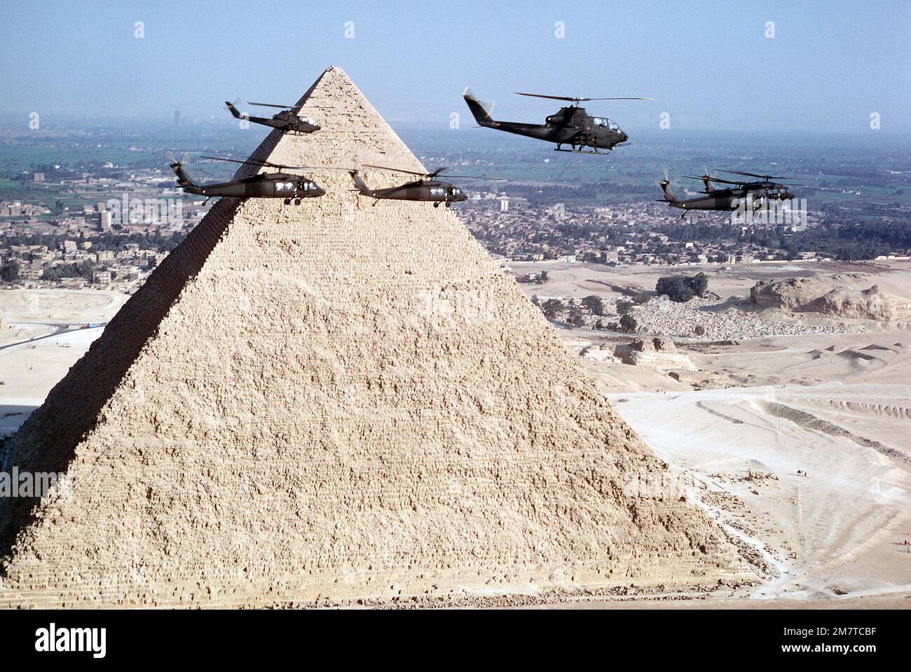 A right side view of UH-60 BlackHawk and AH-1G Cobra helicopters flying ...