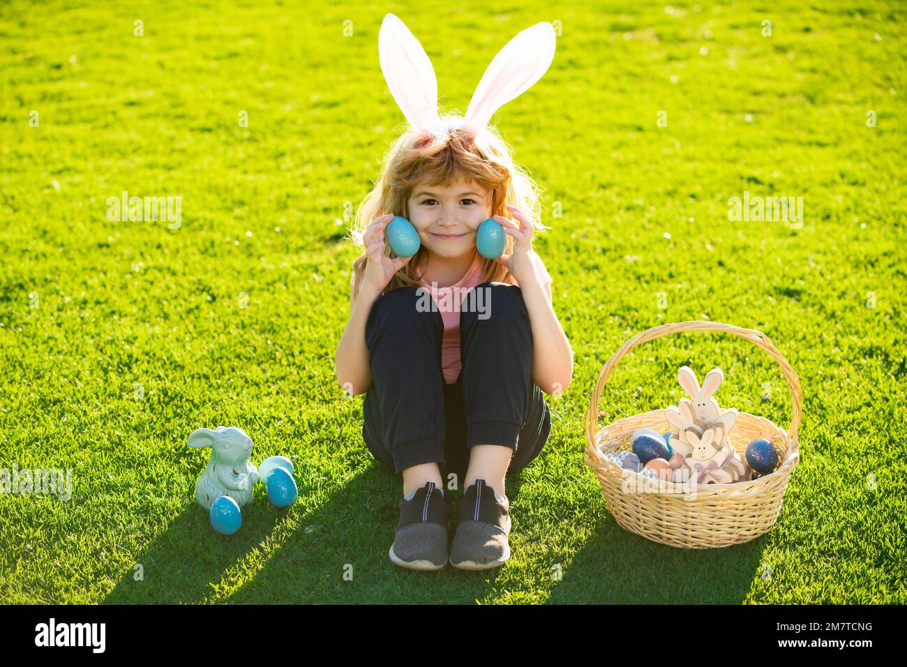 Easter bunny kids. Child boy in bunny Easter ears painting eggs. Funny ...