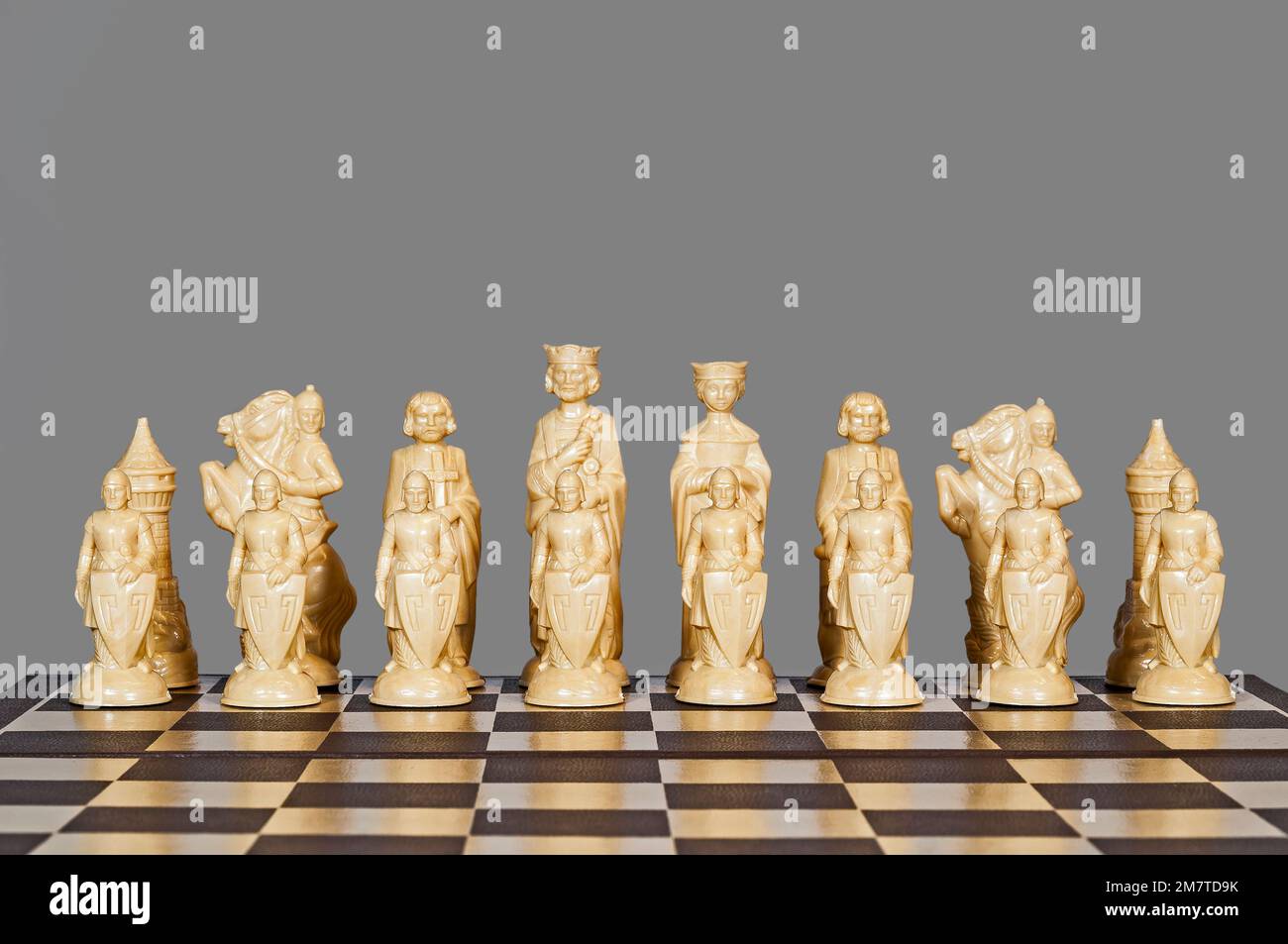 White or light-colored highly detailed chess pieces in initial starting ...