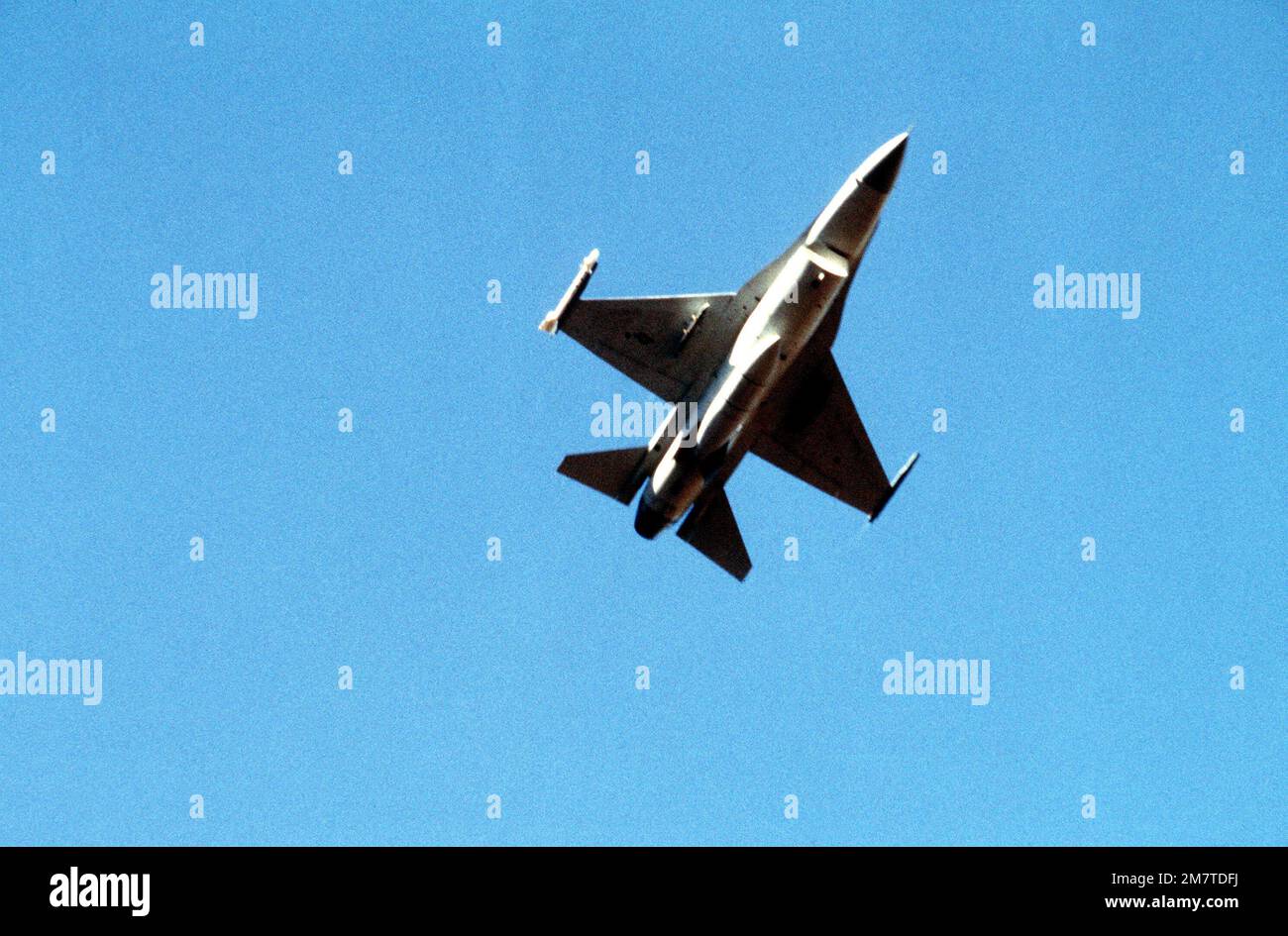 A bottom view of an F-16 Fighting Falcon aircraft carrying an AIM-9 ...